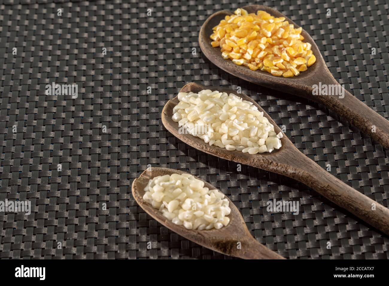 Corn seeds for hominy preparation. Hominy in yellow and white in wooden ...