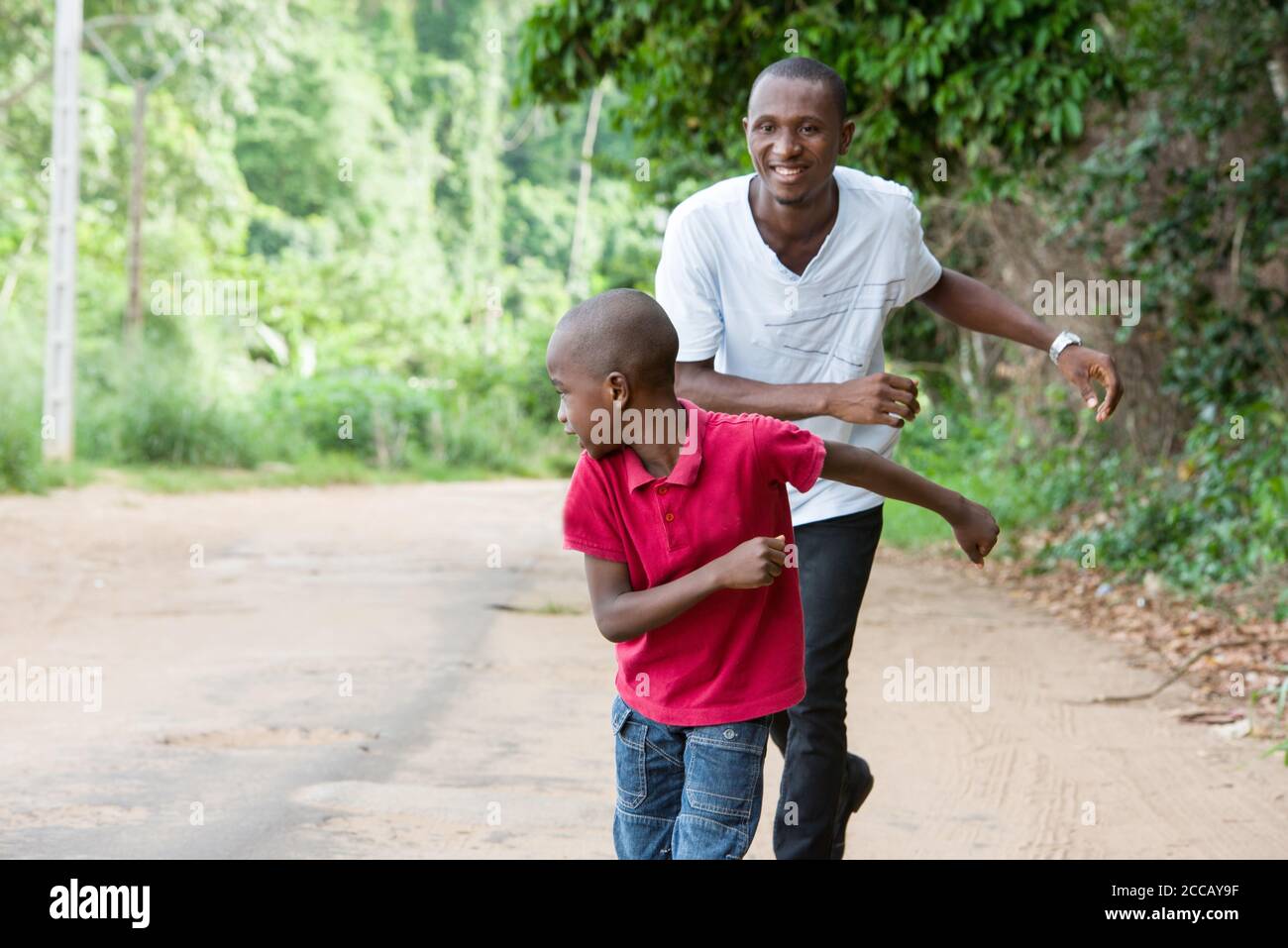 happy family, father and son having fun running outside on a forest ...