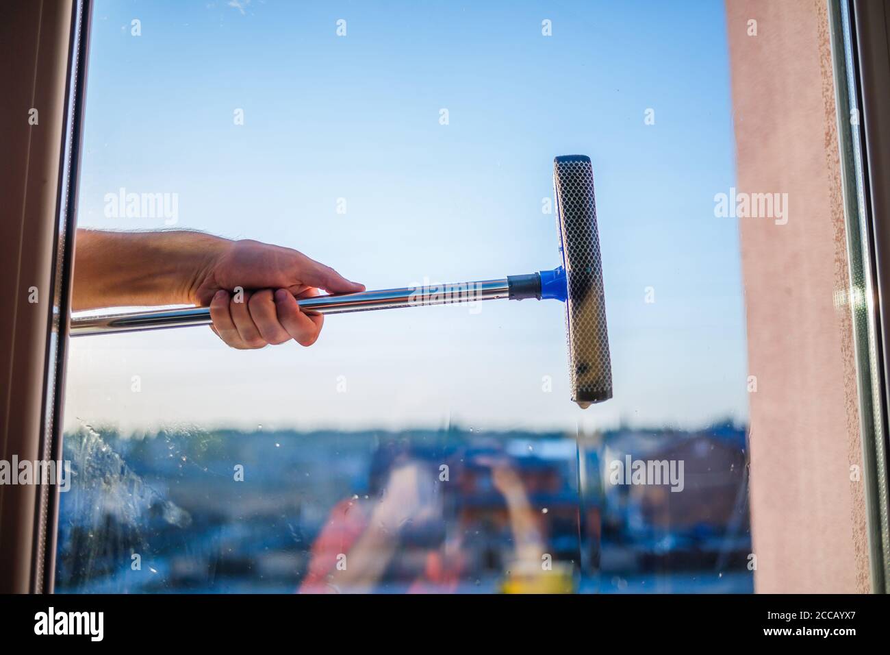 Window cleaning in high-rise buildings, houses with a brush. Window ...