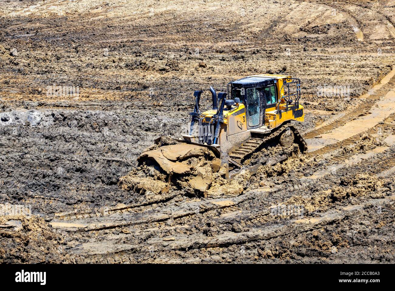 Bulldozer in excavation pit leveling the ground at a construction site ...