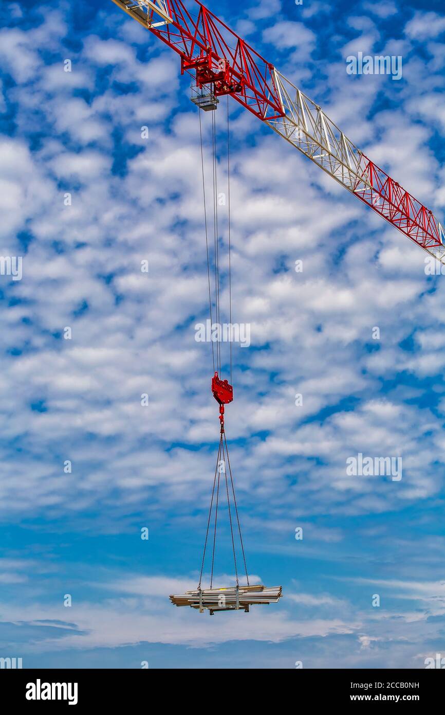 Crane lifting scaffolding elements for installing with sky background ...