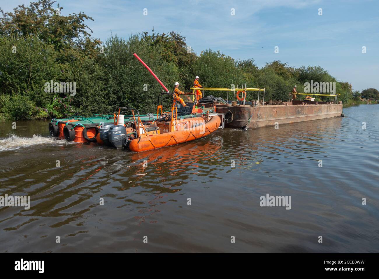 CRT river and canal maintenance workers pushing a supply barge with a ...
