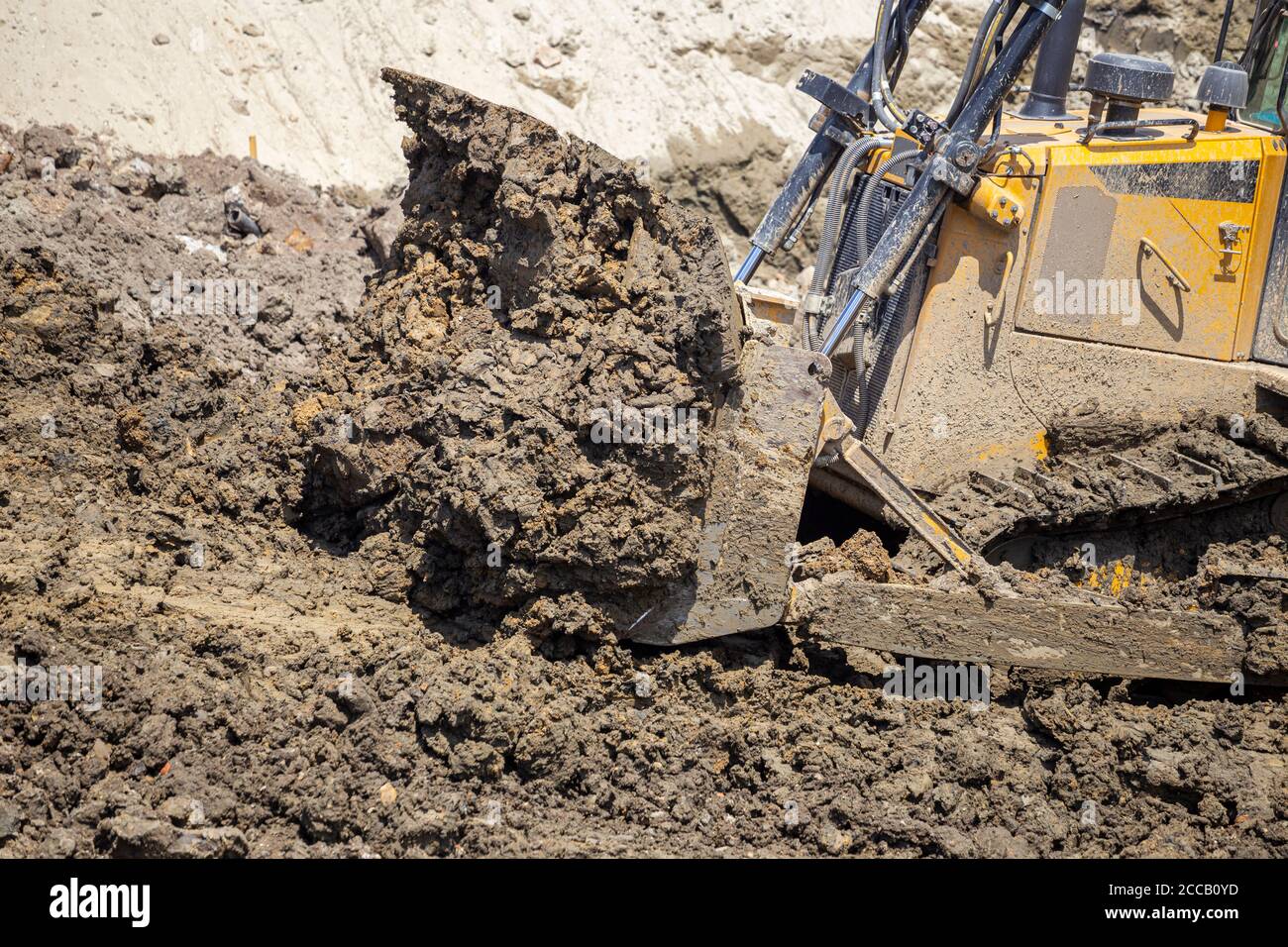 Heavy metal blades of Bulldozer move mounds of dirt at a construction ...