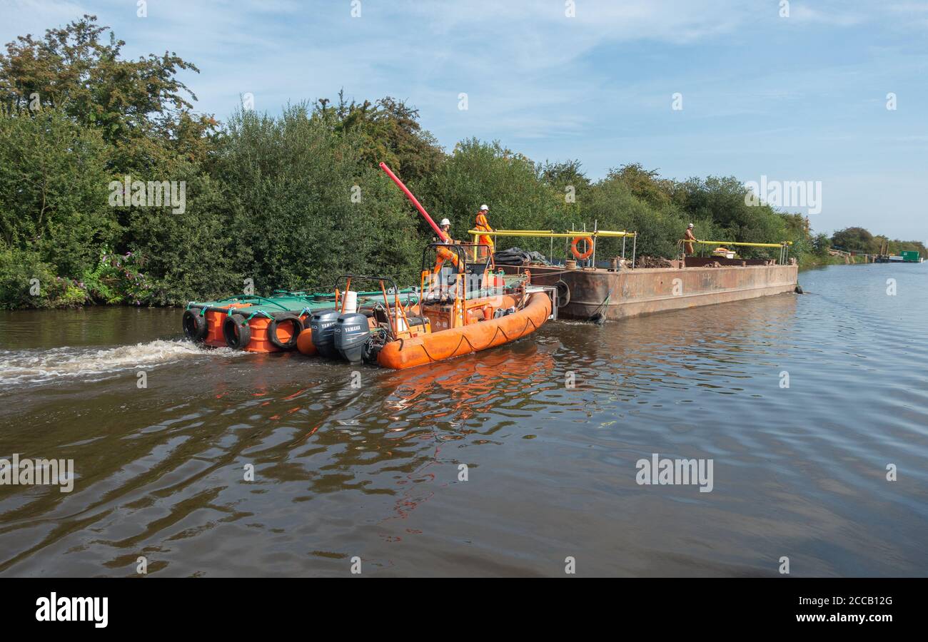 CRT canal and river maintenance workers pushing river supplies barge ...