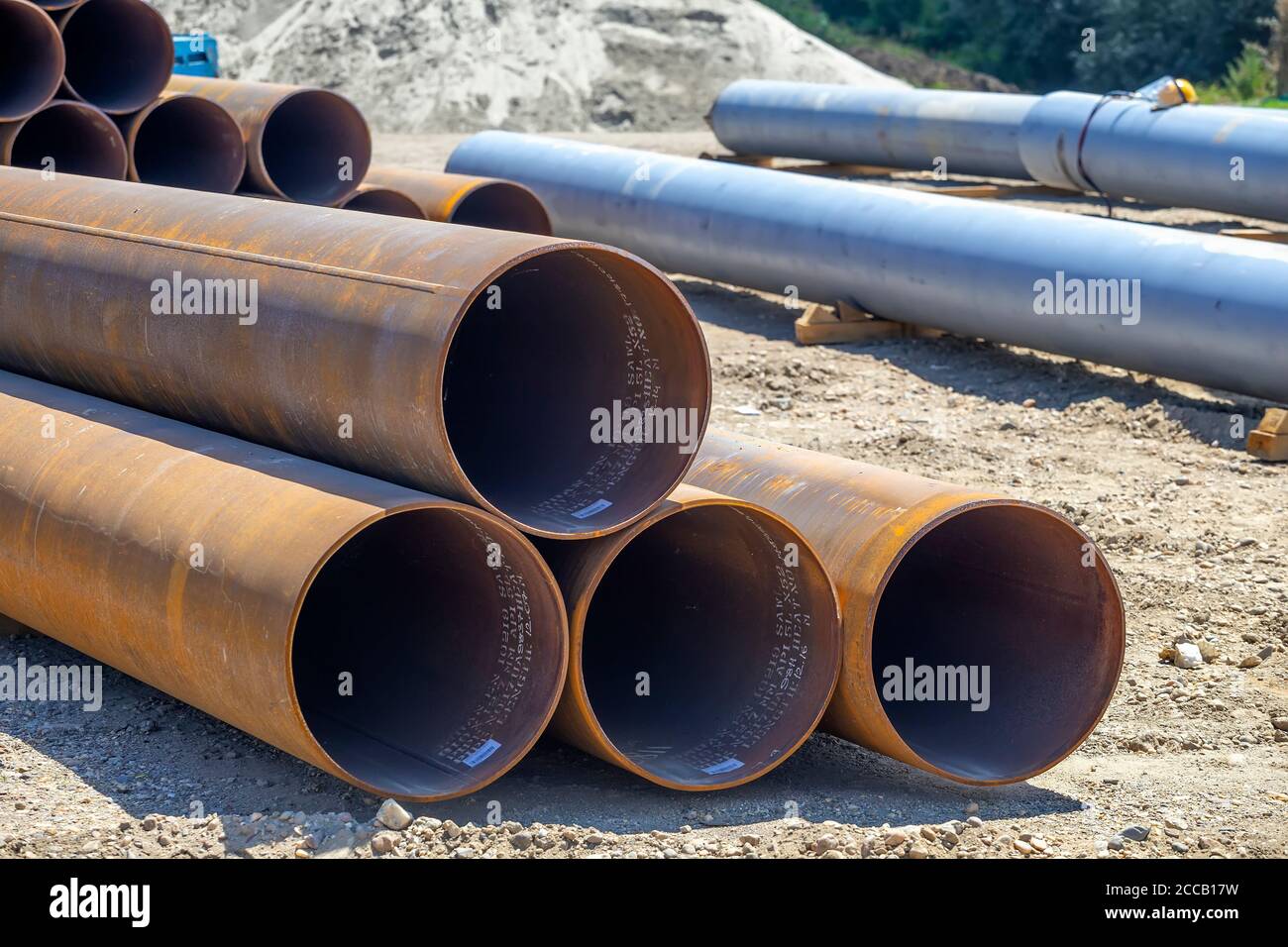Metal pipes laying on the ground for new heat pipeline of residential ...