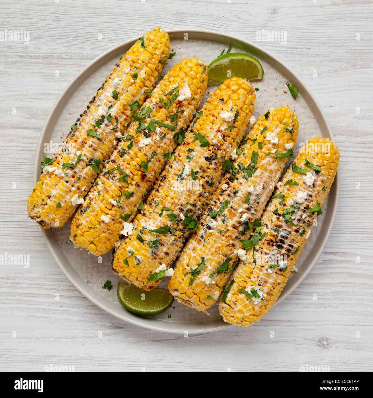 Homemade Elote Mexican Street Corn on a plate on a white wooden table ...