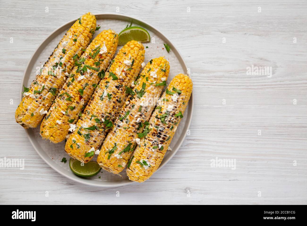 Homemade Elote Mexican Street Corn on a plate on a white wooden ...