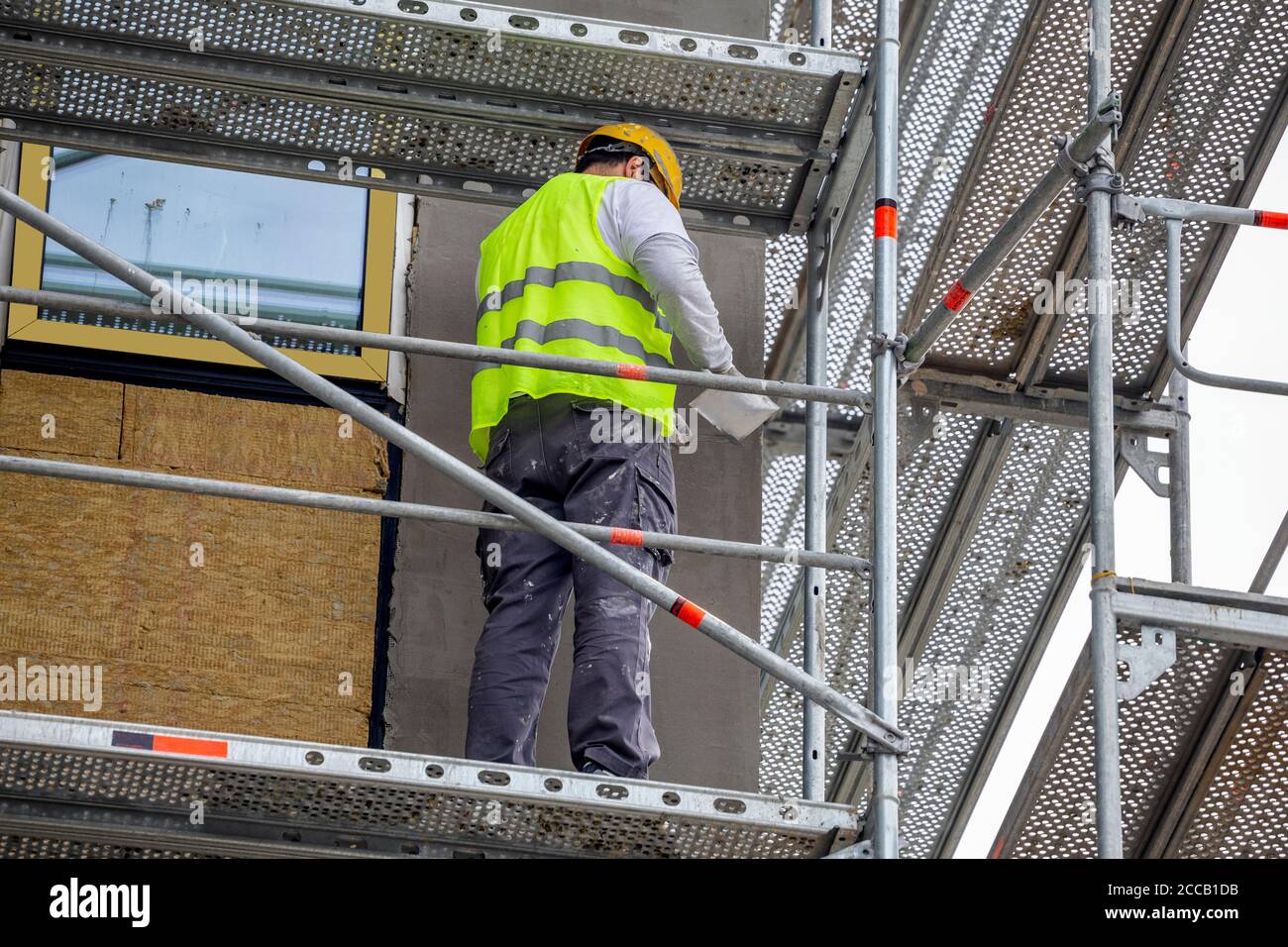 Plastering the wall outdoor on scaffold at building under construction ...