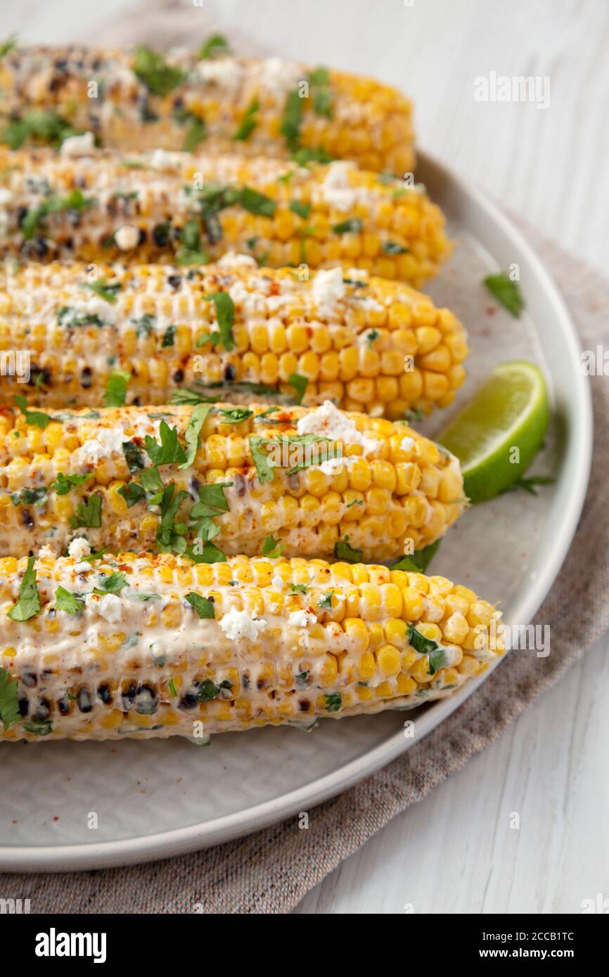 Homemade Elote Mexican Street Corn on a plate, side view Stock Photo ...