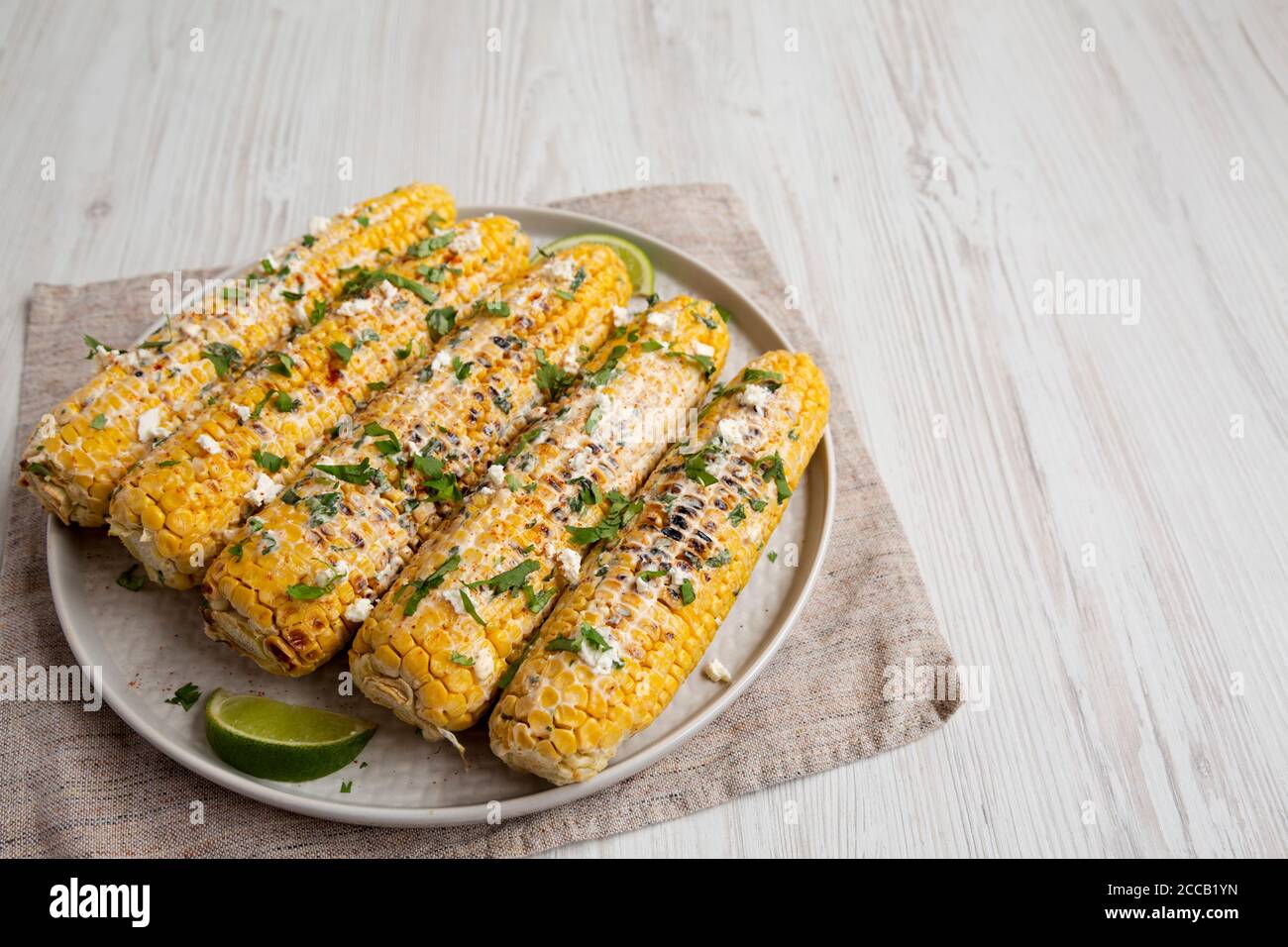 Homemade Elote Mexican Street Corn on a plate, side view. Space for ...