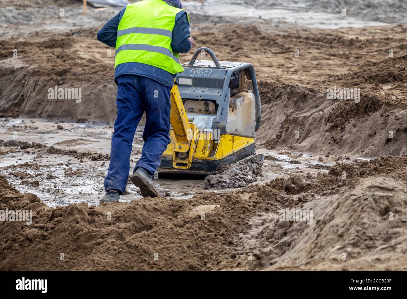 Vibrating machine compacting soil at the construction site Stock Photo ...