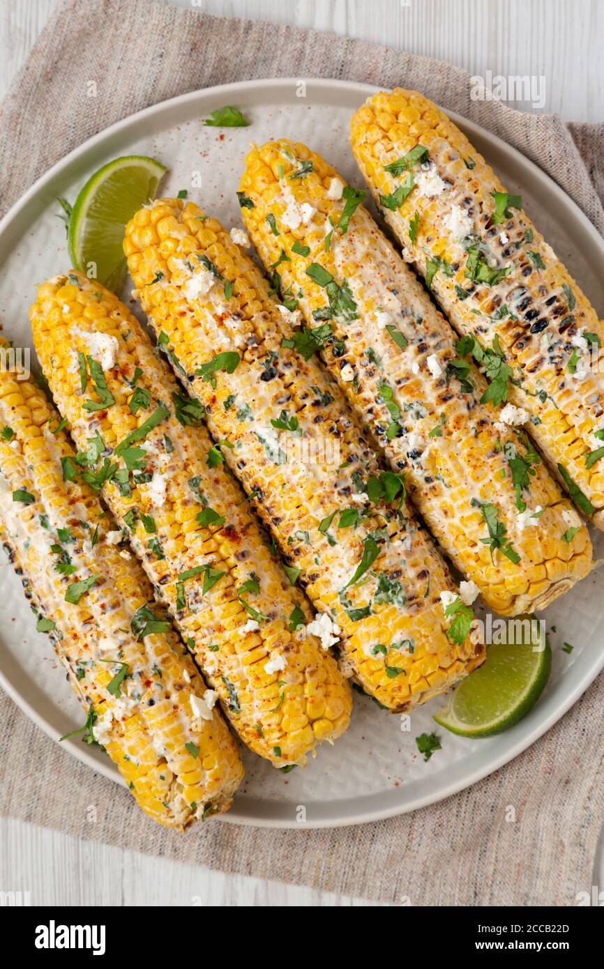 Homemade Elote Mexican Street Corn on a plate on a white wooden ...