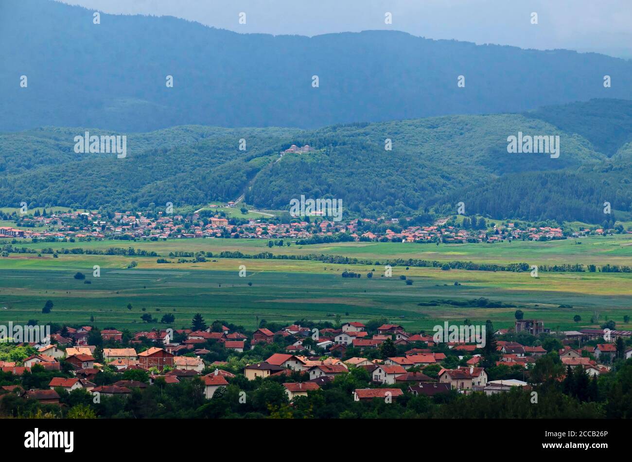 Summer scene with meadow, forest, the Bulgarian villages Alino, Belchin ...