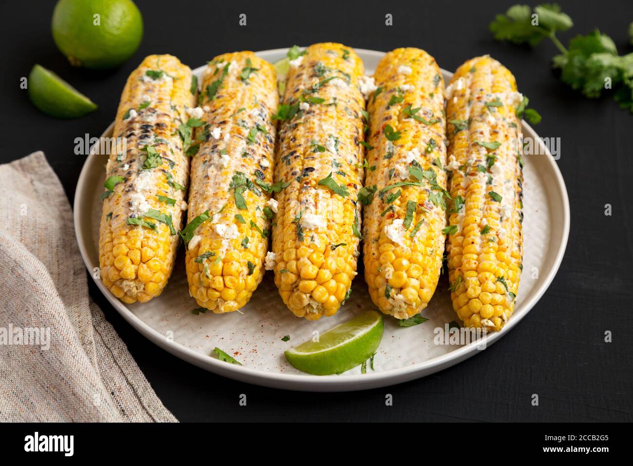 Homemade Elote Mexican Street Corn on a plate on a black background ...