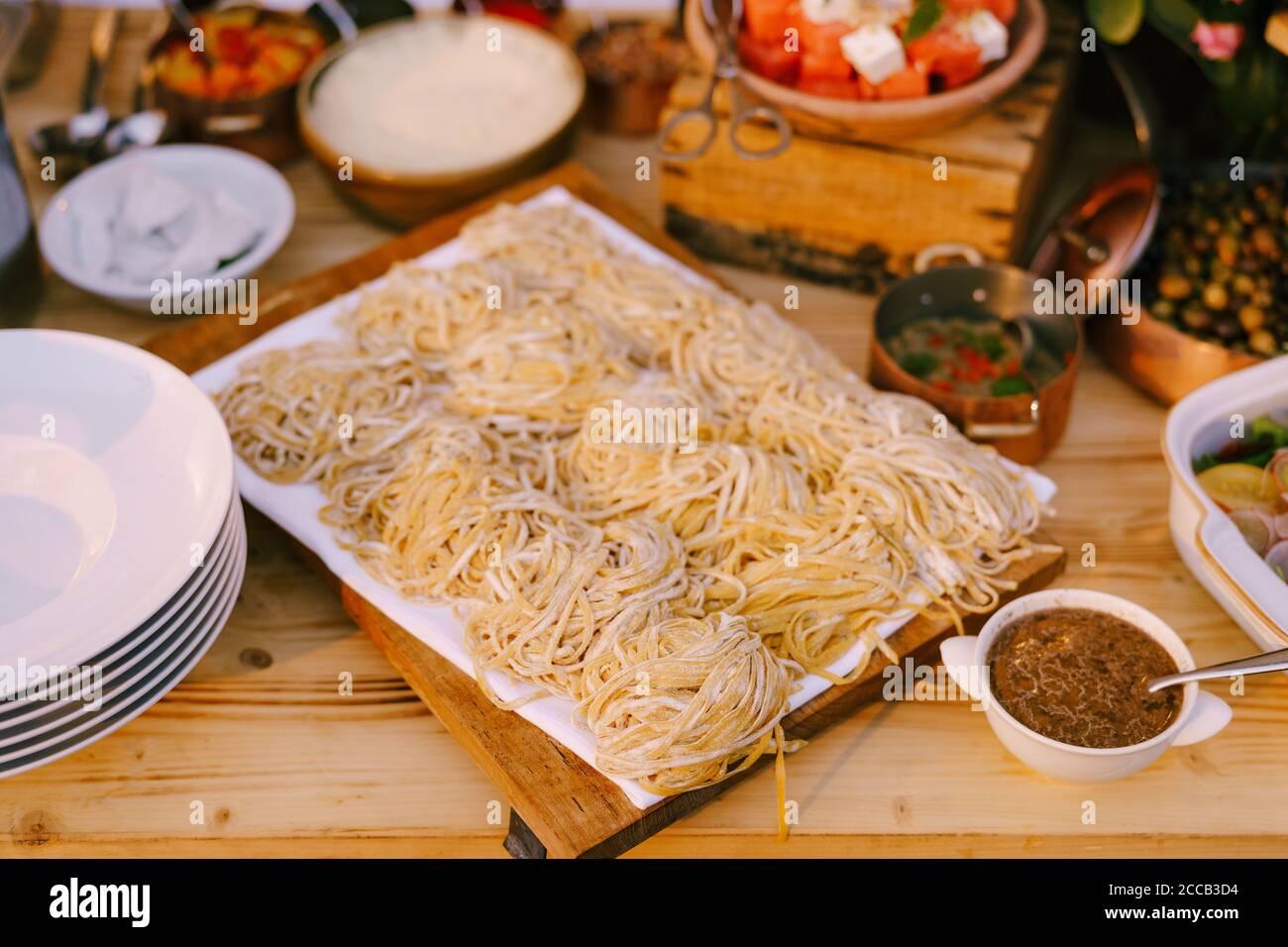 Spaghetti on a wooden plank for cutting with cooked meals and clean ...