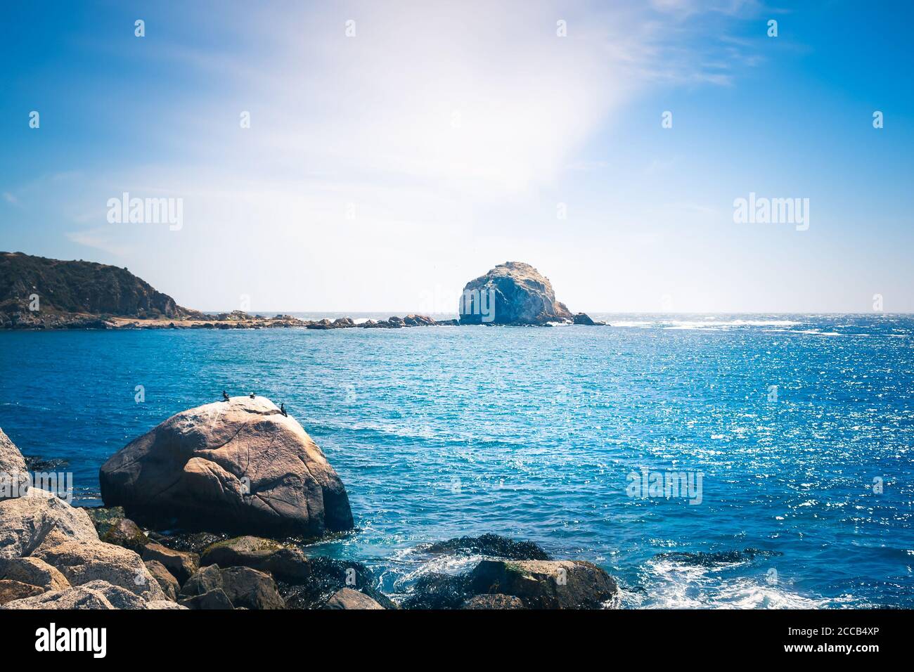 View of the pacific ocean with rocky island and stones on the ...