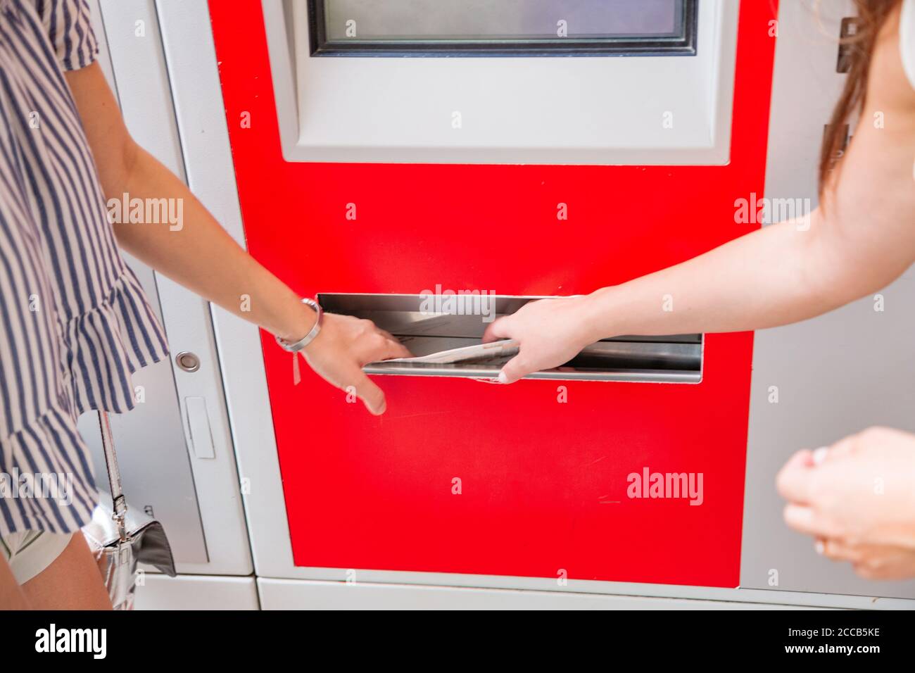 Female hands buying taking train ticket from a red ticket machine Stock ...