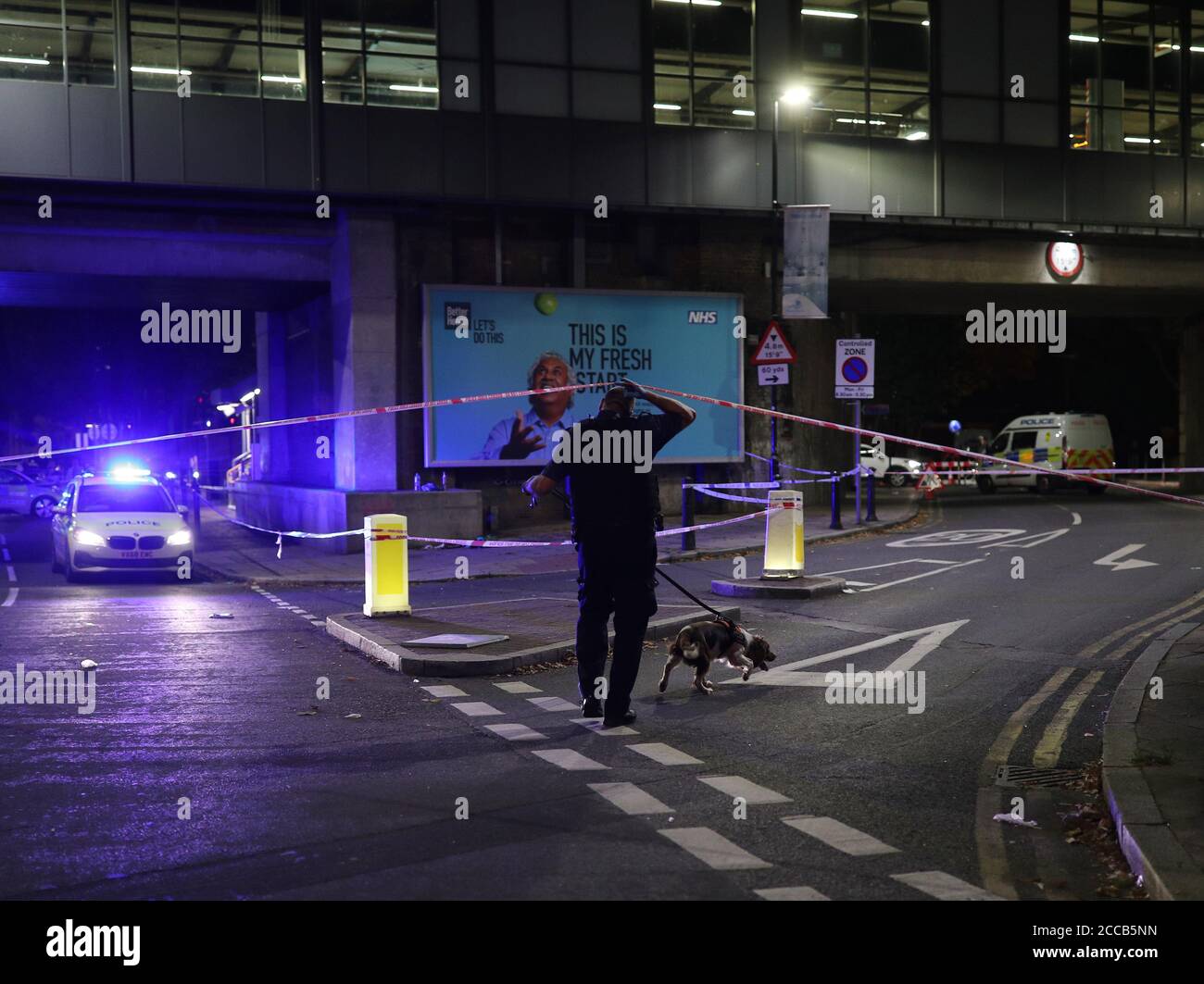 A police dog handler at the scene of a stabbing outside Westferry DLR ...