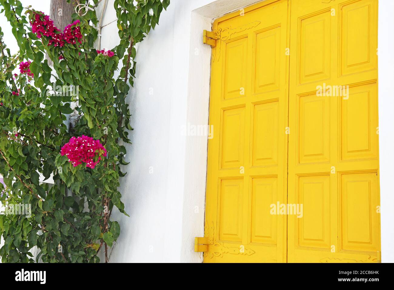 traditional yellow window and bougainvillea flower at Ano Koufonisi ...
