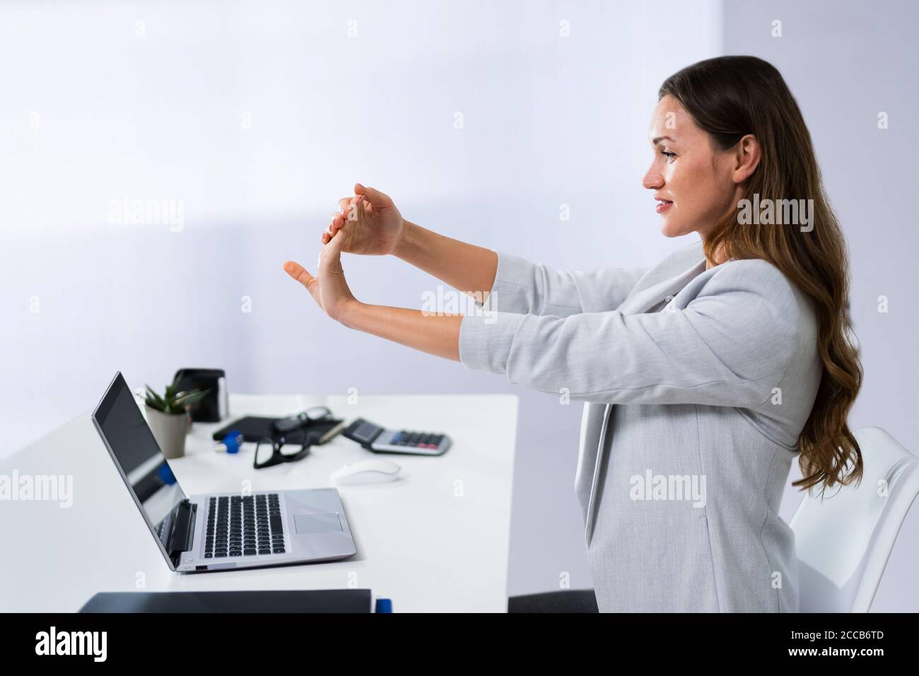Business Woman Doing Stretch Exercise At Office Desk Stock Photo - Alamy