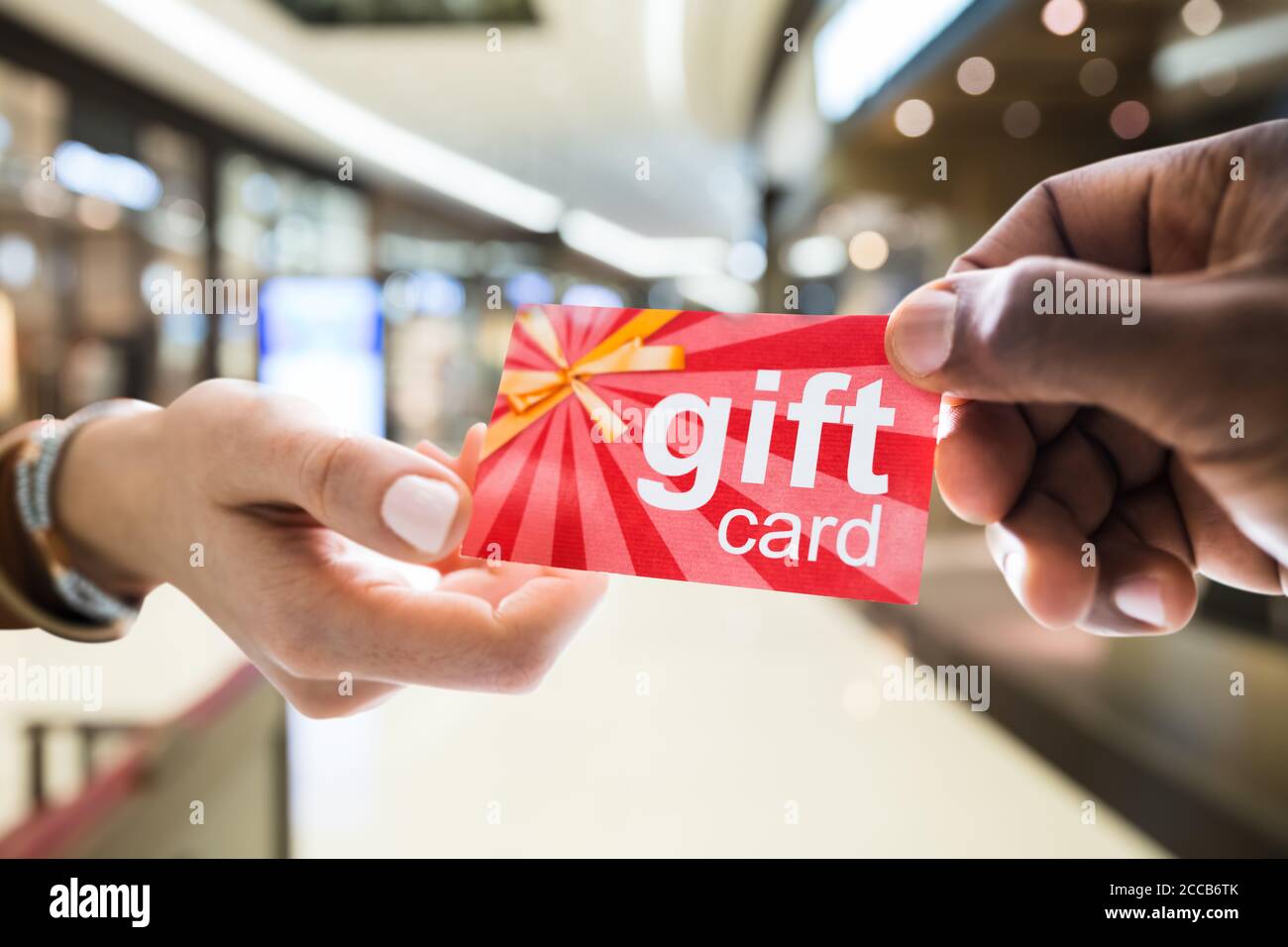 Giving Gift Card Or Voucher In Shopping Mall Stock Photo - Alamy