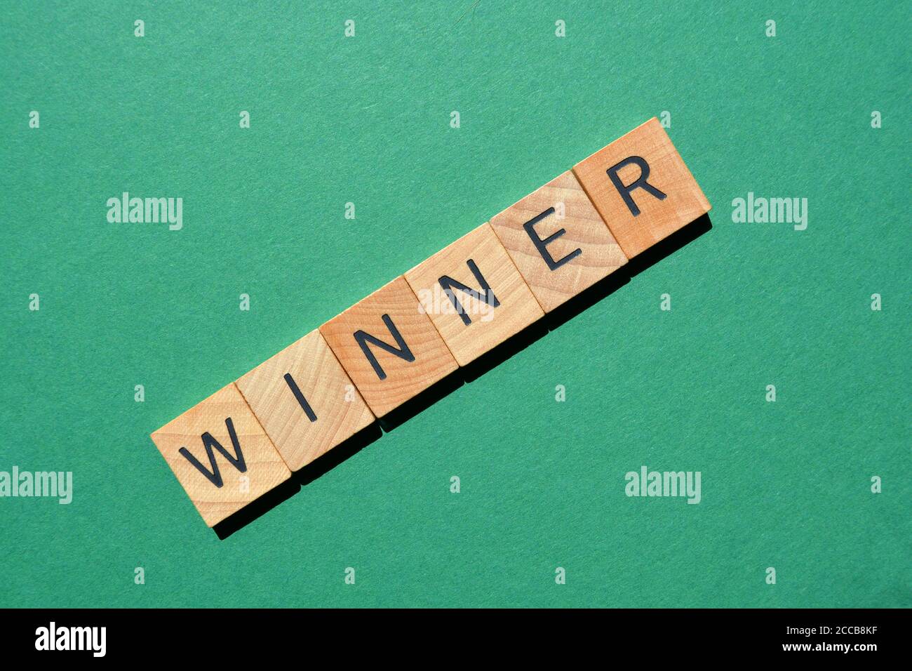 Winner, word in wooden alphabet letters isolated on green background ...
