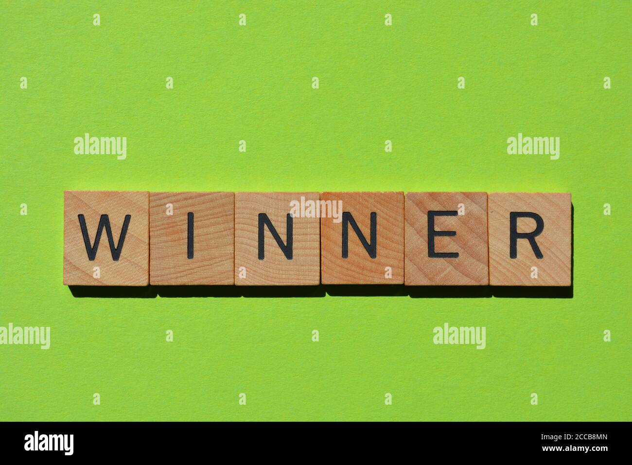 Winner, word in wooden alphabet letters isolated on bright green ...