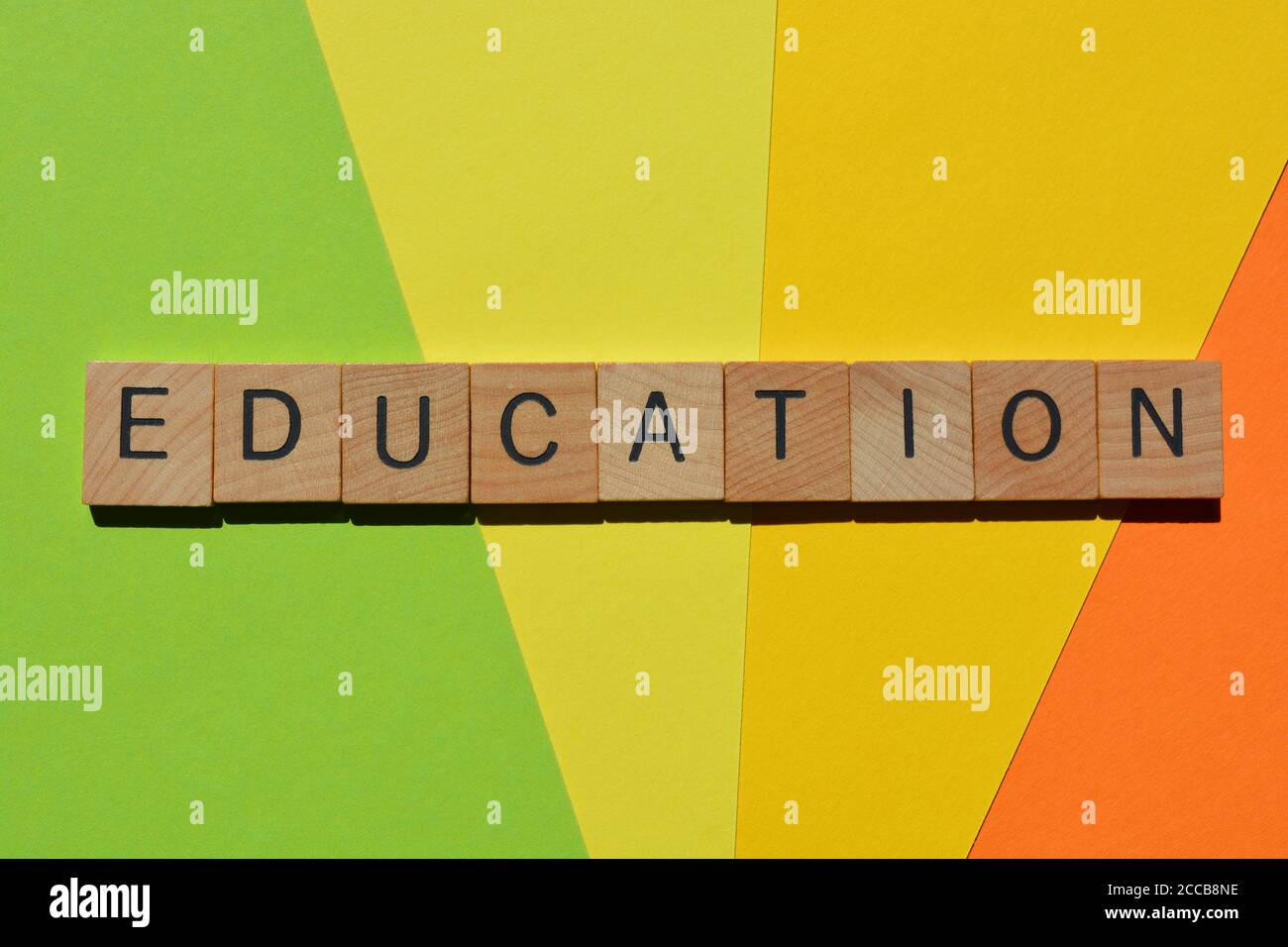 Education, word in wooden alphabet letters isolated on green, yellow ...