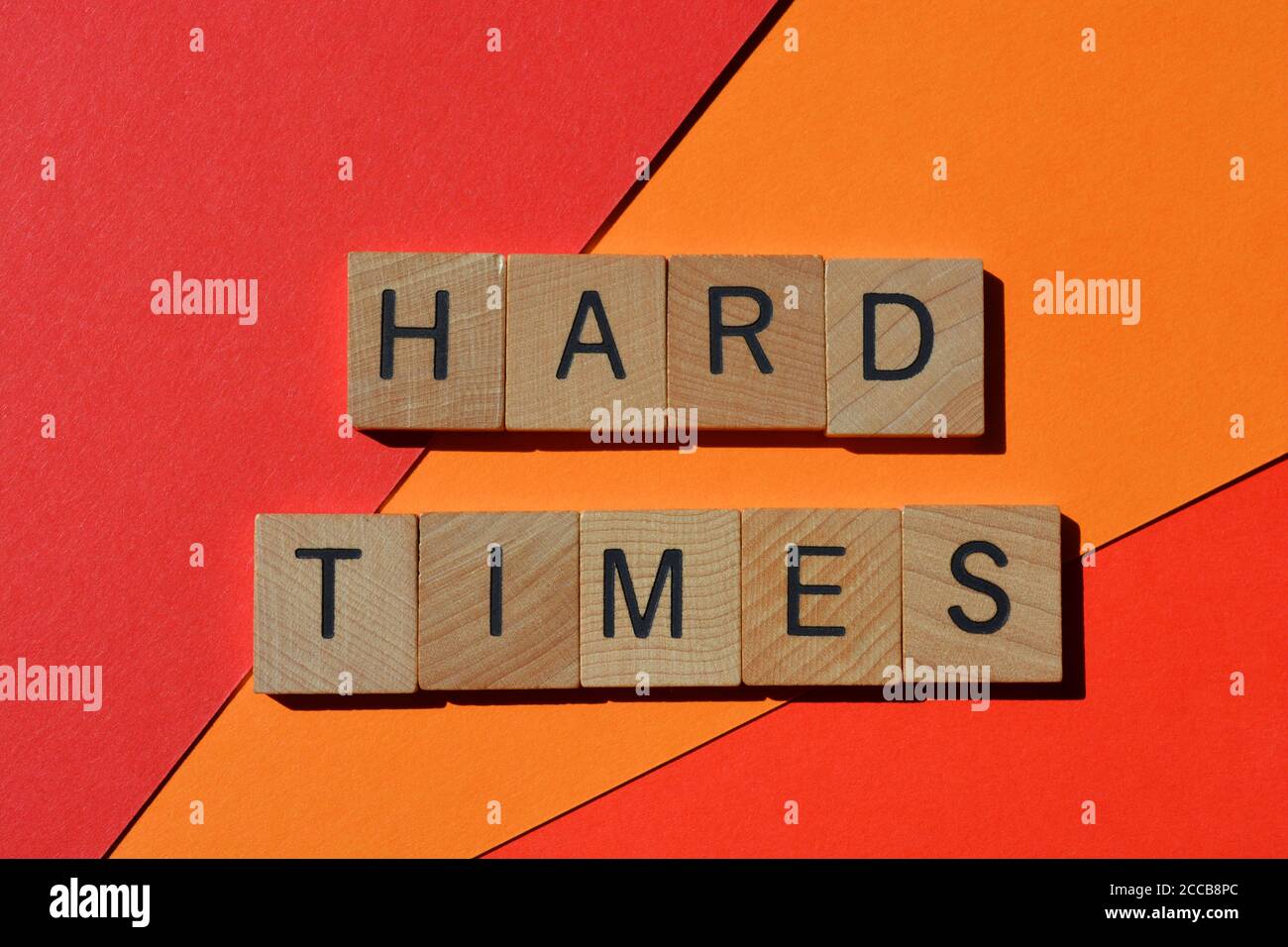 Hard Times, words in wooden alphabet letters on bright red and orange ...