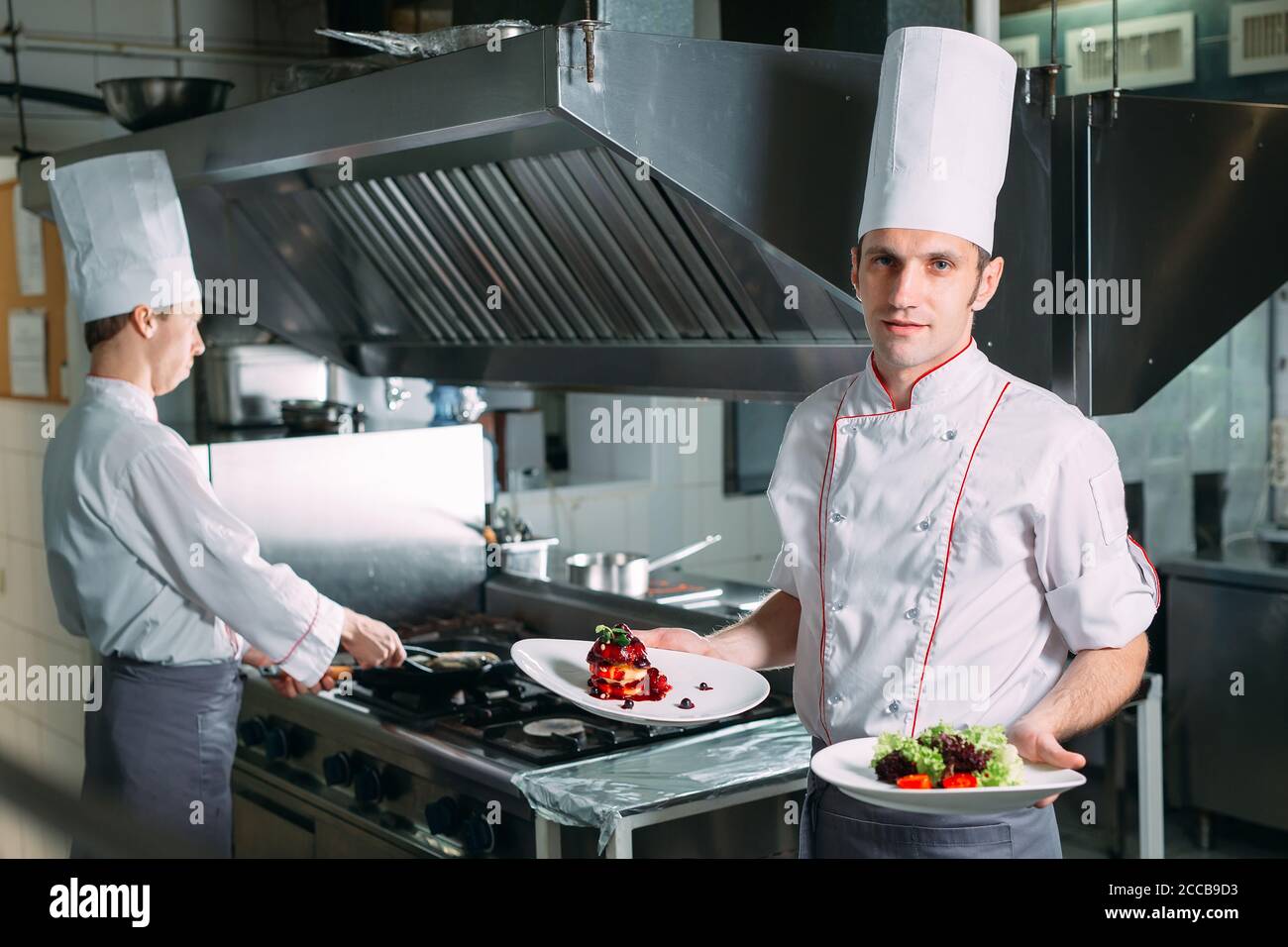 Portrait of the Chef in the kitchen of the restaurant with a ready-made ...