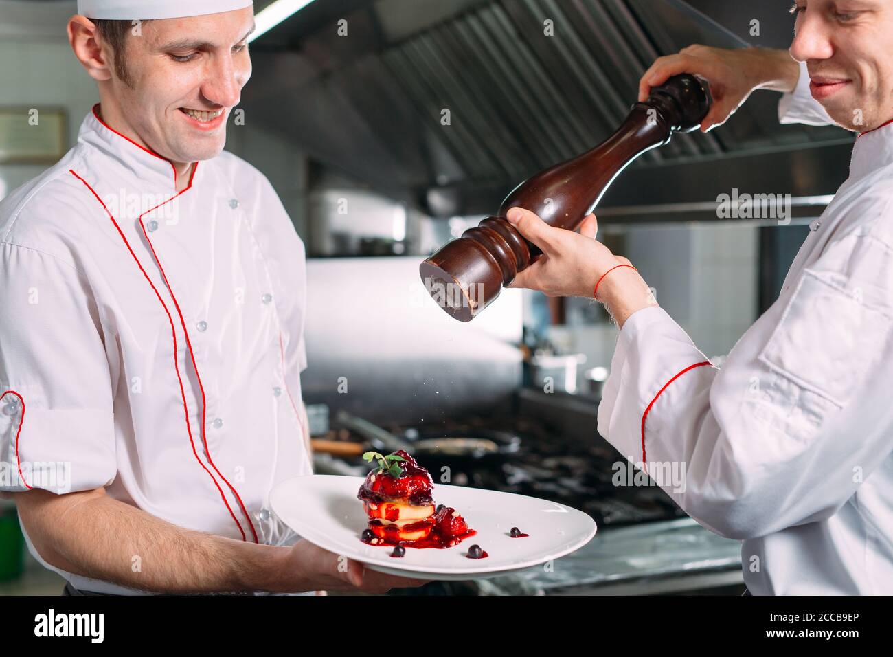 Two Chefs Sha background kitchen pepper dishes Stock Photo - Alamy