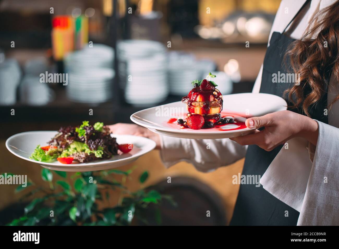 Waiter serving in motion on duty in restaurant. The waiter carries ...