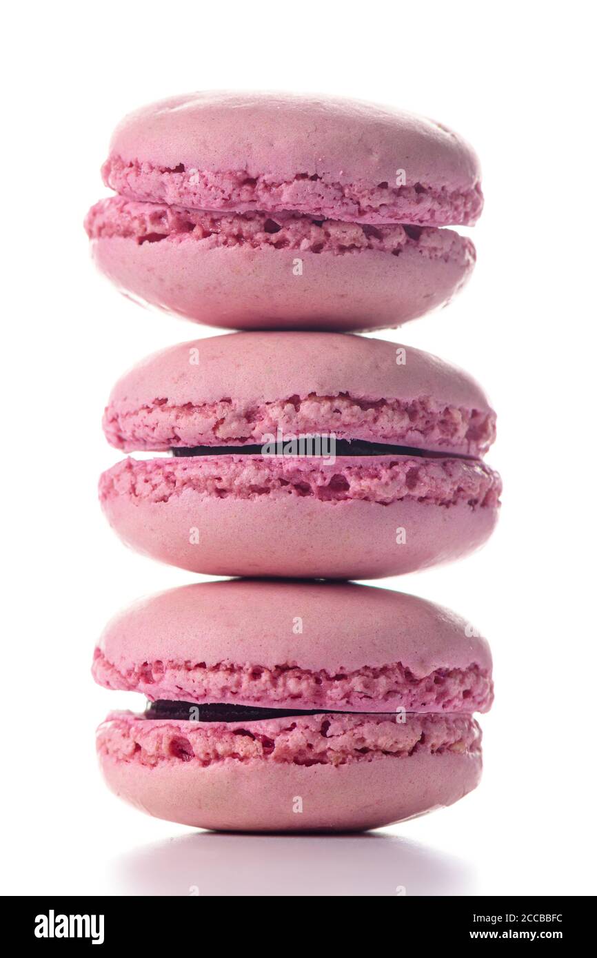Three raspberry flavoured macaroons standing on top of each other on ...