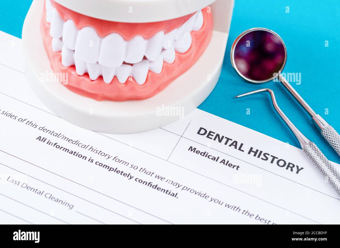 Dental history form with model tooth and dental instruments. Dental ...