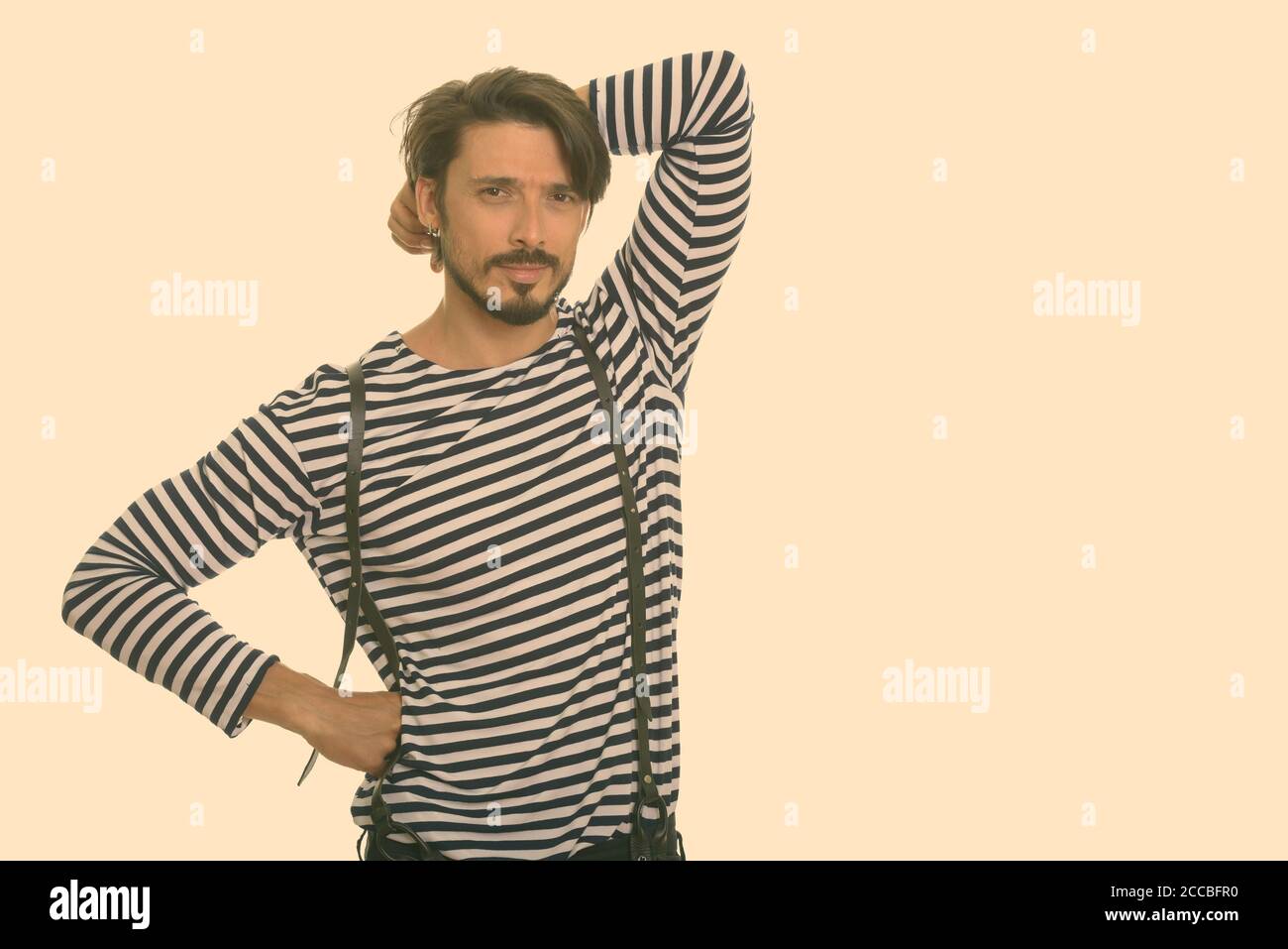 Studio shot of handsome man posing with hands on head and hip Stock ...