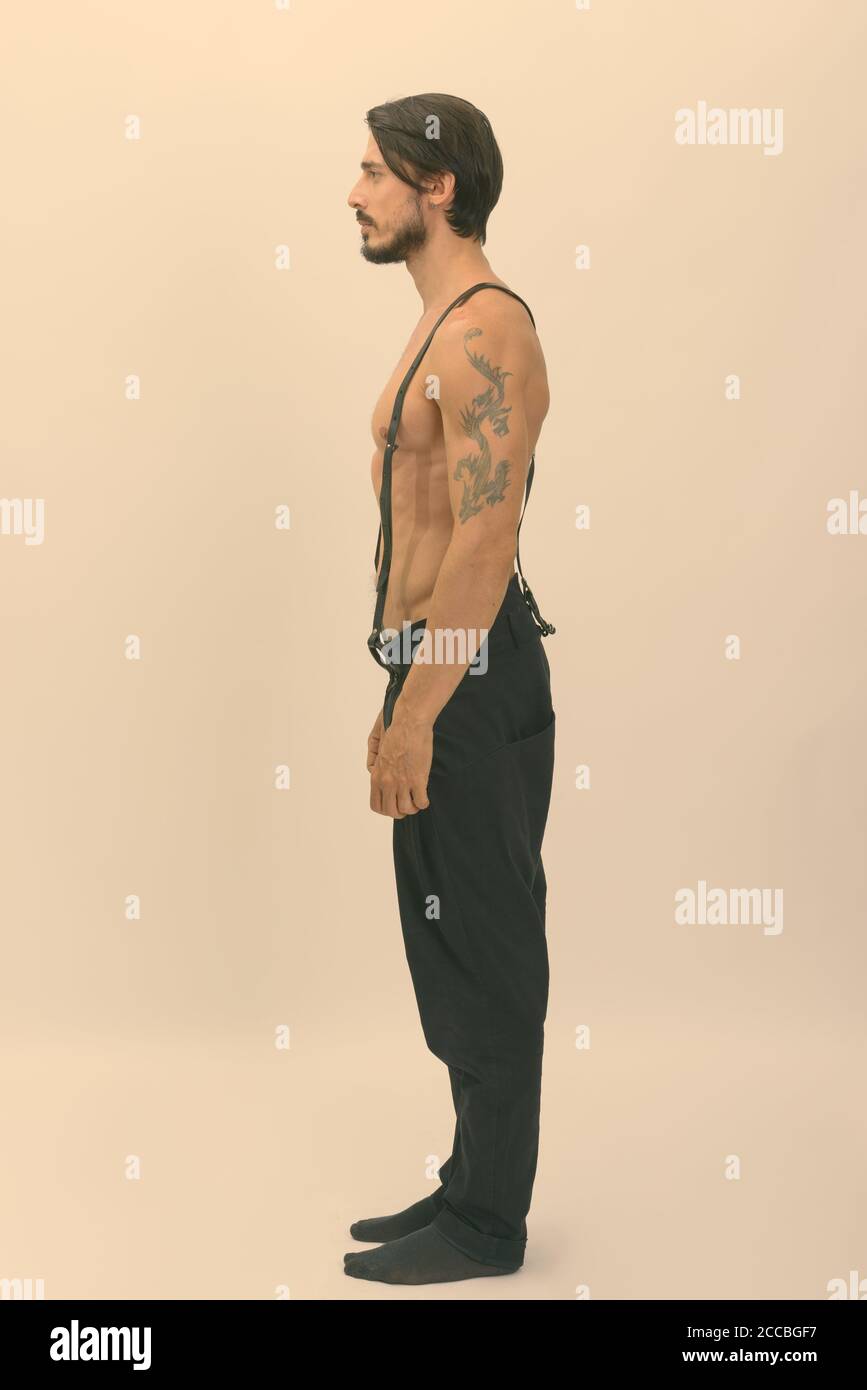 Full body shot profile view of handsome muscular man with suspenders ...