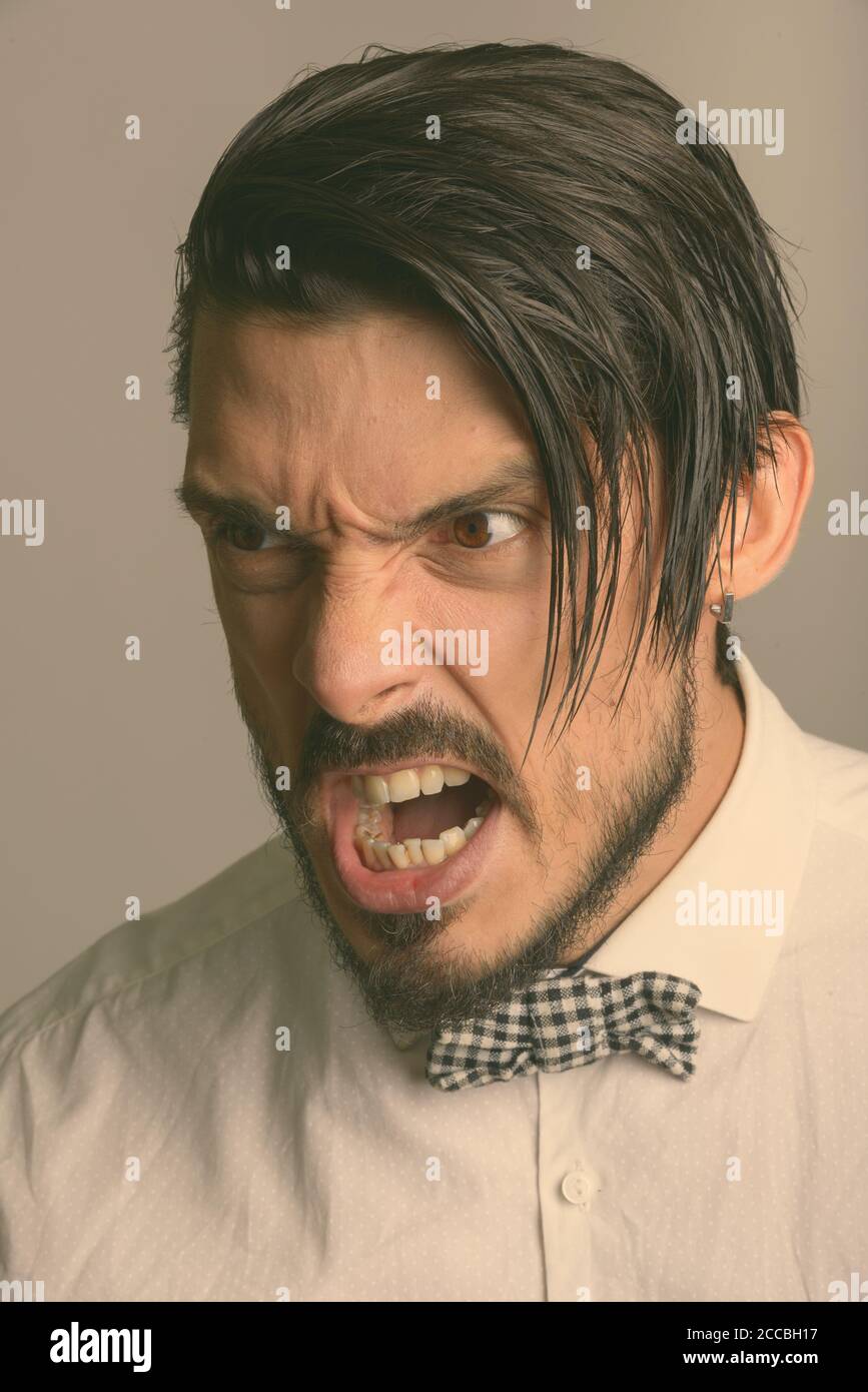Face of stressed young bearded businessman looking angry Stock Photo ...