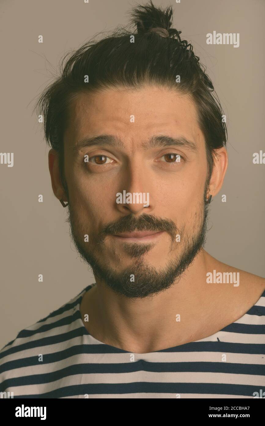 Face of handsome man hair tied back and biting lip Stock Photo - Alamy