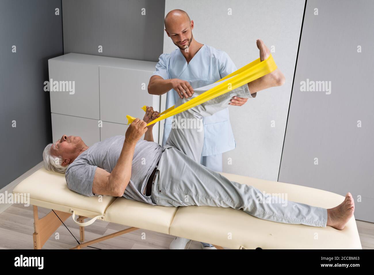 Knee Exercise Therapy And Treatment Using Physical Band Stock Photo - Alamy