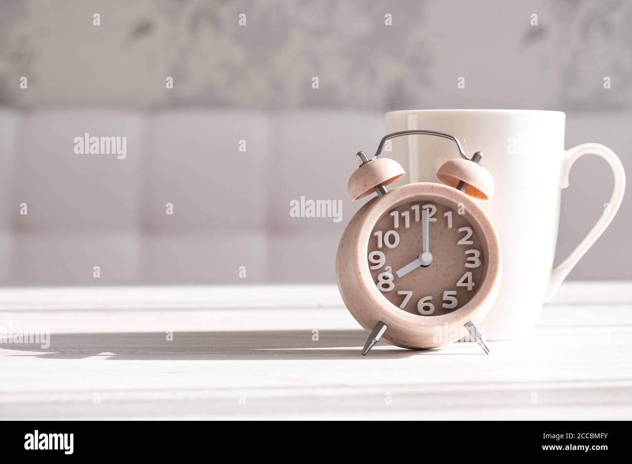 Close-up of an alarm clock and a cup of coffee has a good morning and ...