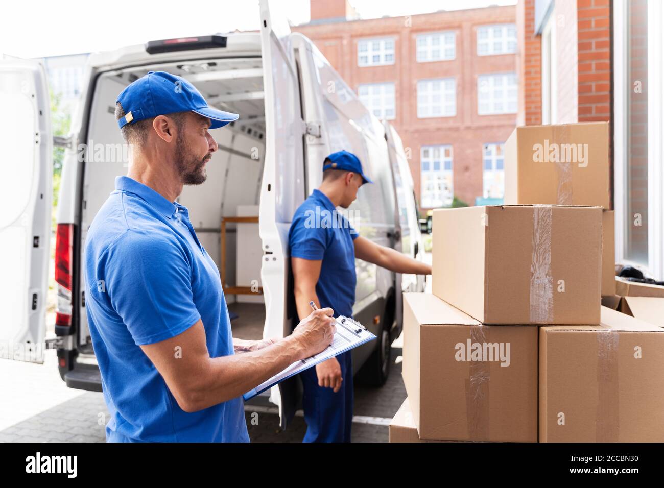 Van Courier And Professional Movers Unload Truck Stock Photo - Alamy