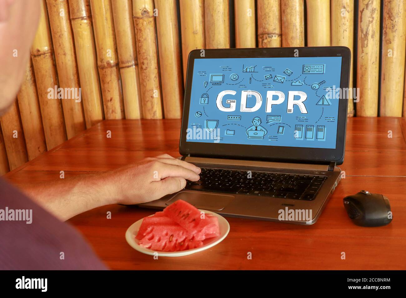 GDPR concept, laptop on a table, blue screen. A man works at laptop and ...