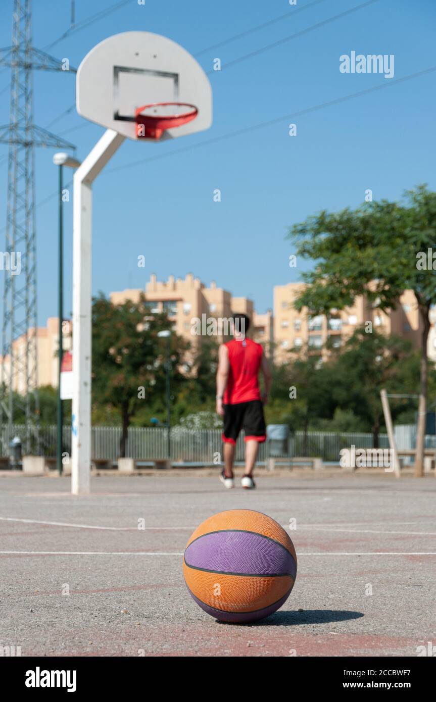 Vertical selective focus shot of a basketball in a court with the male ...