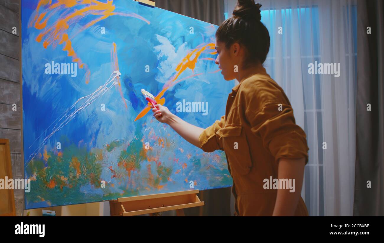 Confident young painter using hand technique on new painting Stock ...