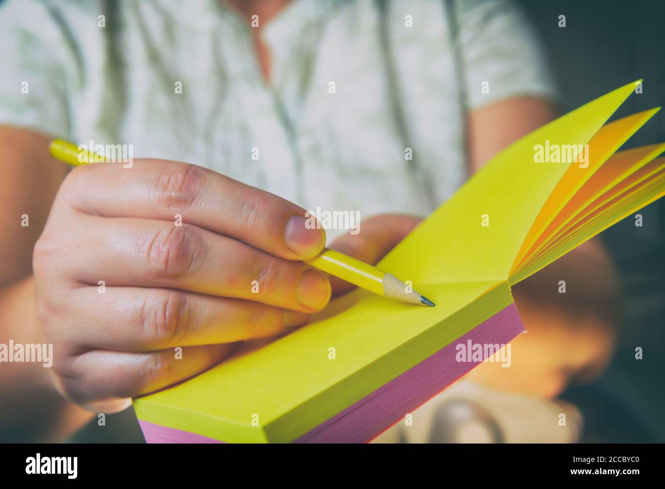 Woman taking notes with yellow pencil. Close up on the notepad Stock ...