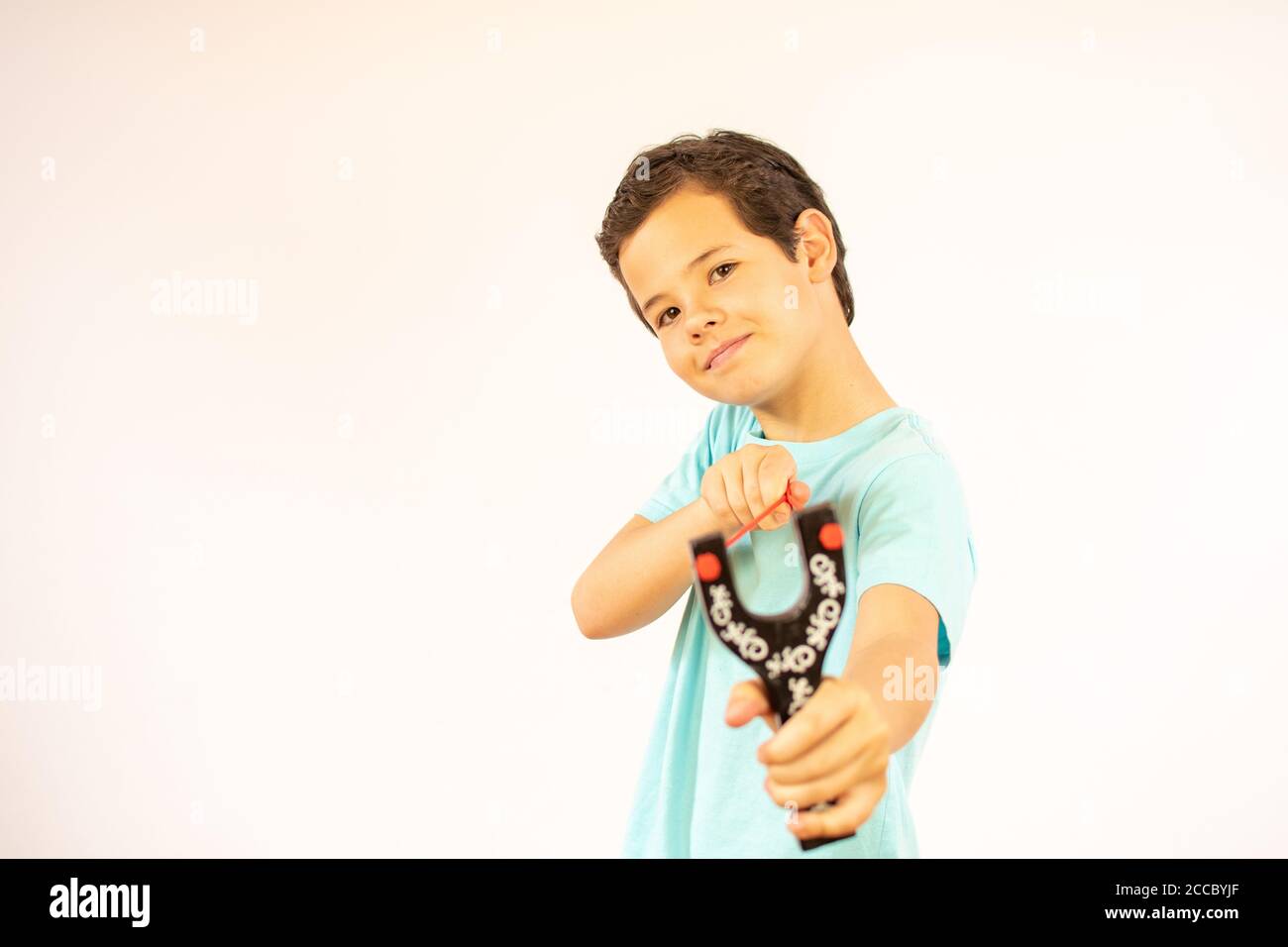 Handsome boy playing with a slingshot Stock Photo - Alamy