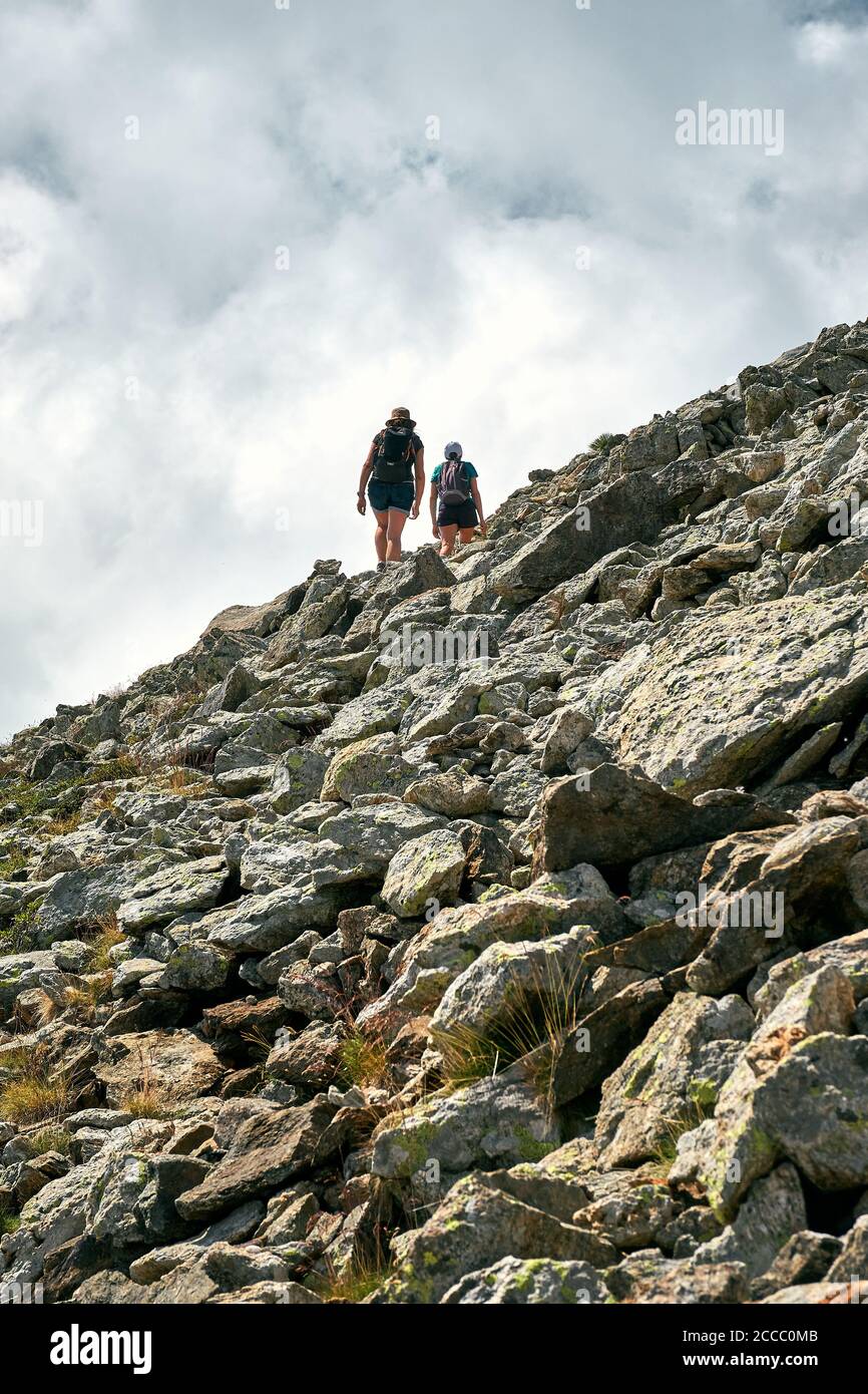 Back view photo of hikers climbing a slope of a mountain in the French ...