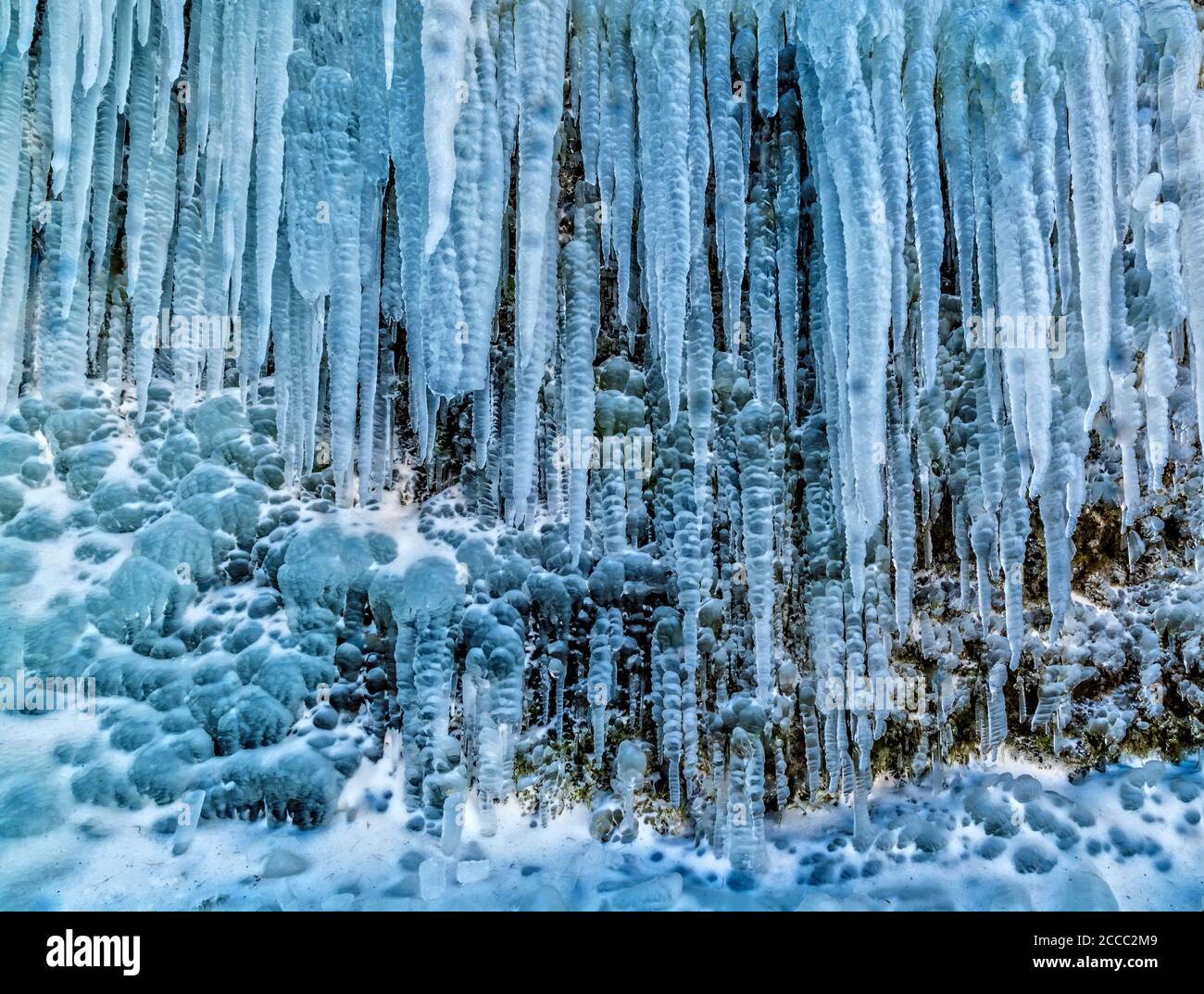 Detail of massive group of icicles on rock. Beautiful frozen water ...
