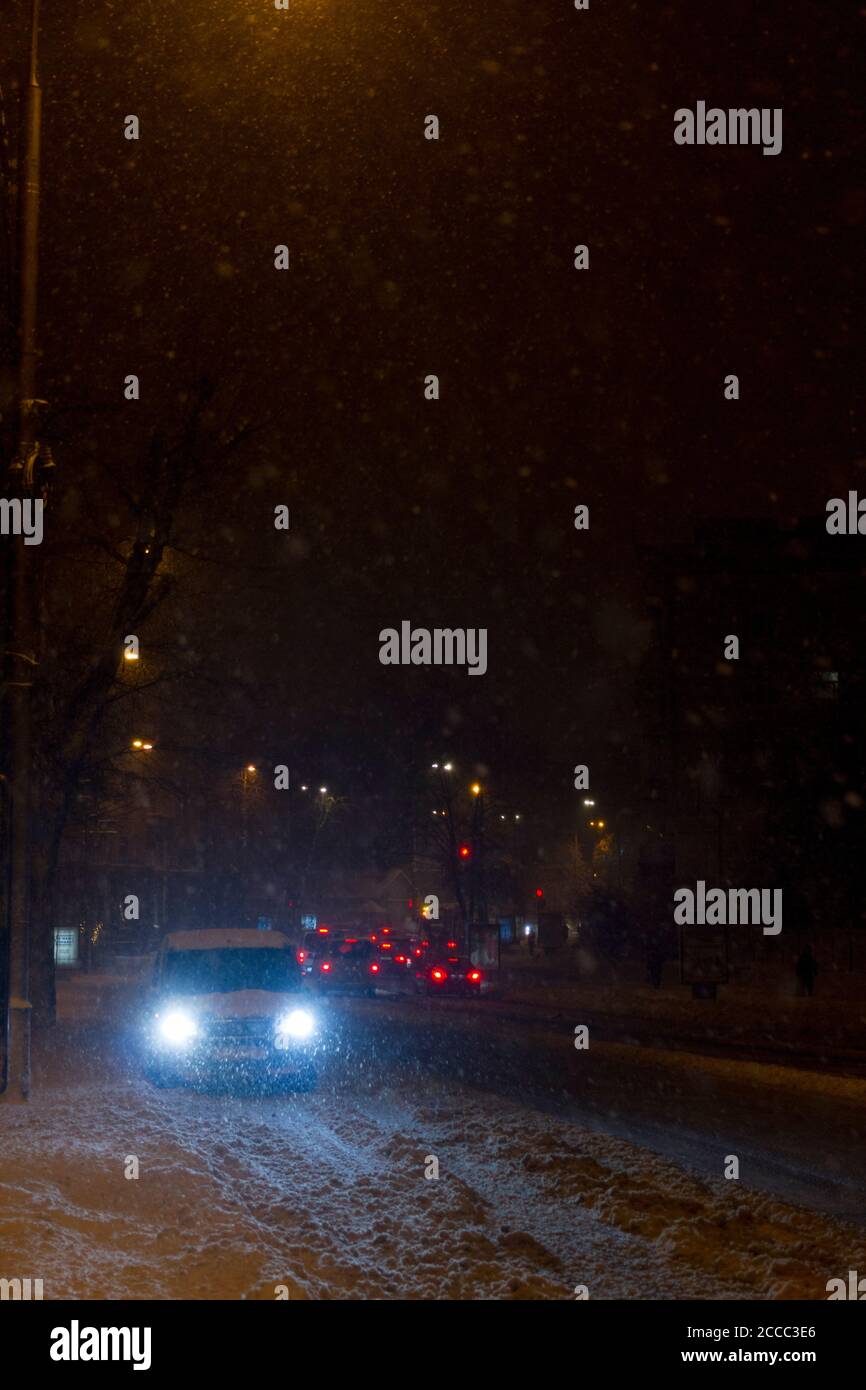 Winter snow storm. Traffic jam at night. Car blurred at the street ...
