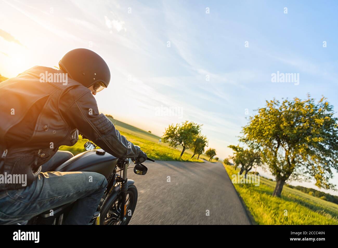Dark motorbiker riding high power motorbike in nature with beautiful ...